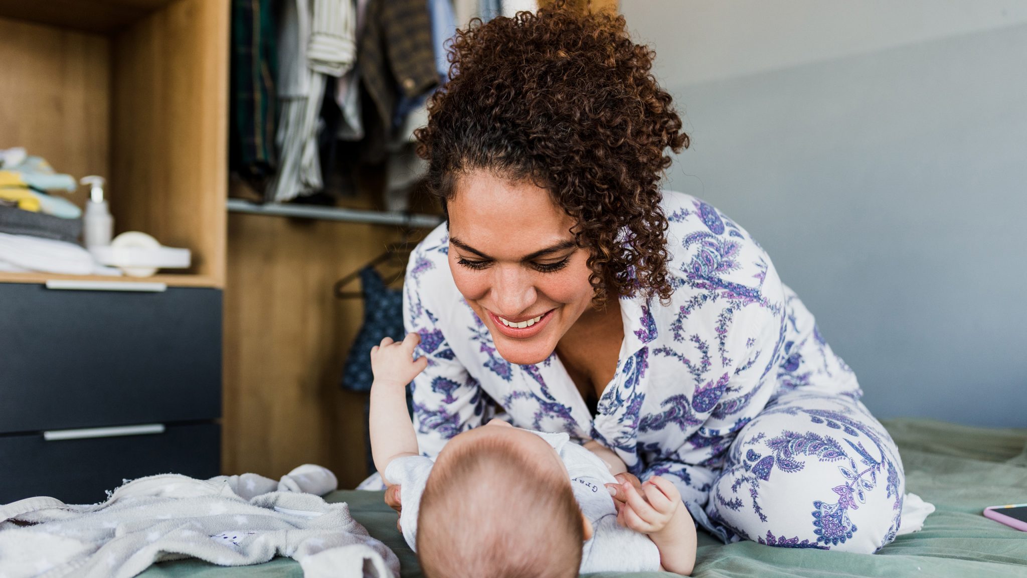 smiling-parent-leaning-over-their-baby-smiling - Early Learning Nation